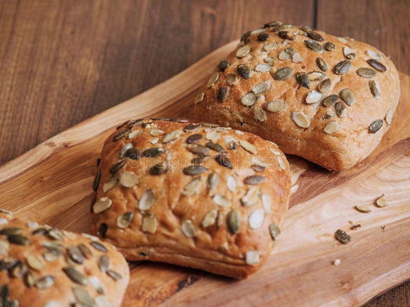 Small Bread Rolls on a Wooden Board and Table, Close Up. Stock Photo ...