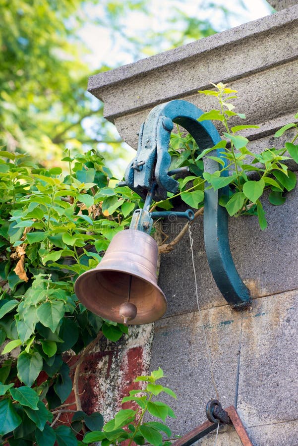 Small Bronze Bell on a Stone Wall Stock Image - Image of suspend ...