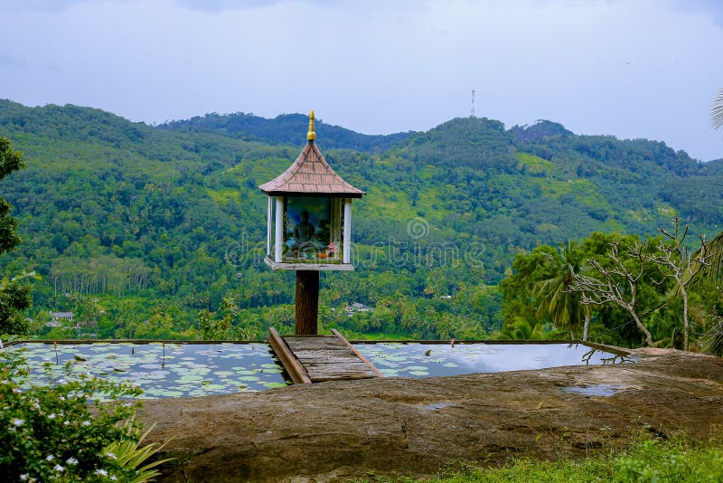 A Small Buddha Statue Set in the Middle of a Beautiful Hilly Landscape ...