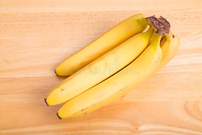 Small Bunch of Yellow Bananas on Wood Table Stock Image - Image of ...
