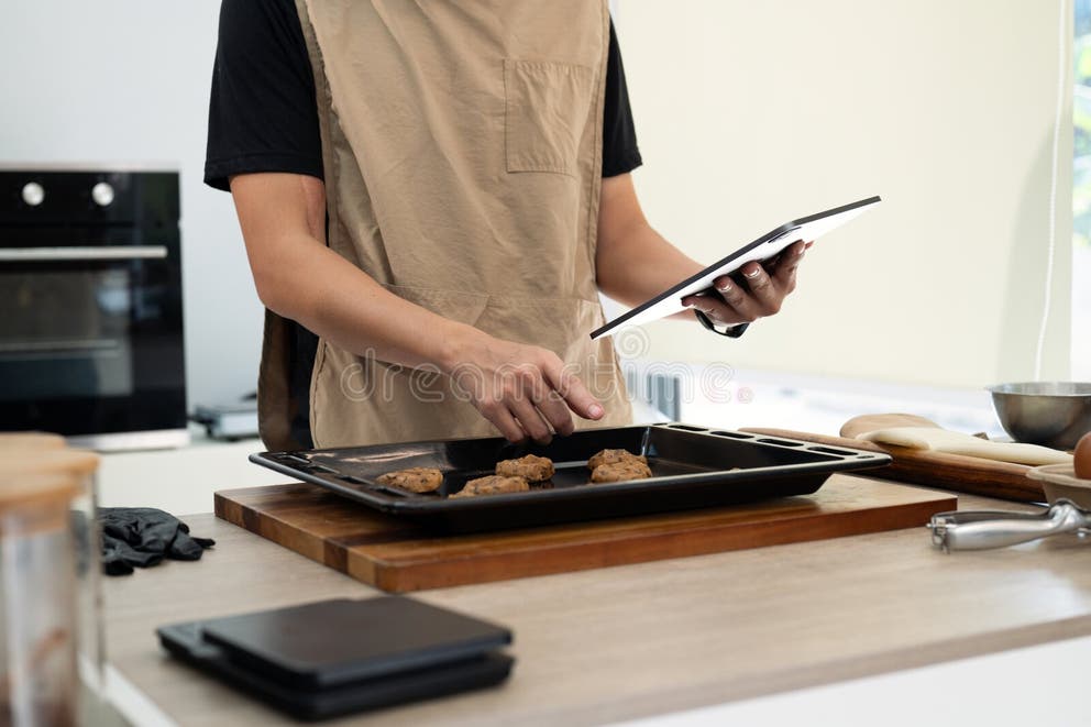 Small Business Owner Checking Orders on Digital Tablet while Preparing ...