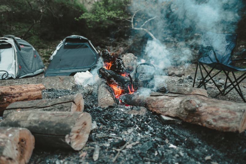 Small Camp with Smoke from Campfire by Waterfall. Stock Photo - Image ...