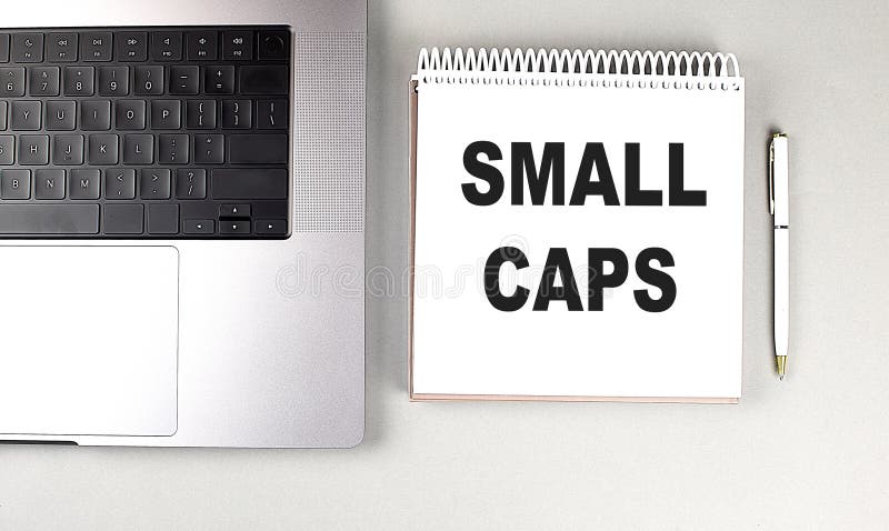SMALL CAPS Text on Notebook with Laptop and Pen Stock Photo - Image of ...