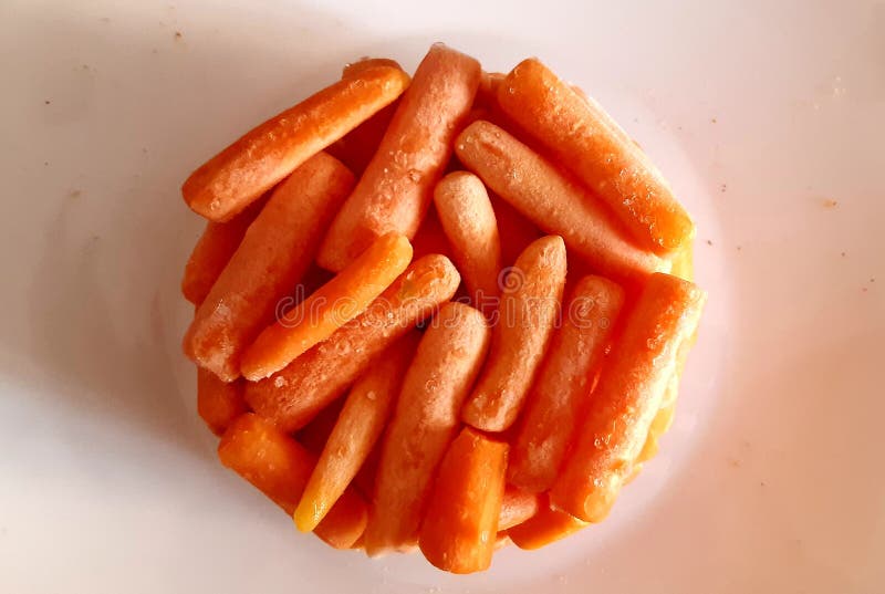 Small Carrots Stacked in a Circular Shape on a Plate. Stock Photo ...