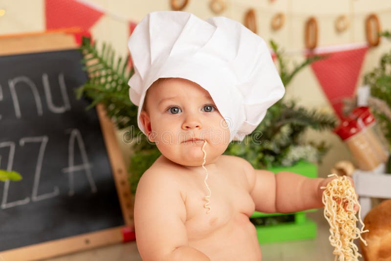 A Small Child Cook in a Hat in the Kitchen among the Products and ...