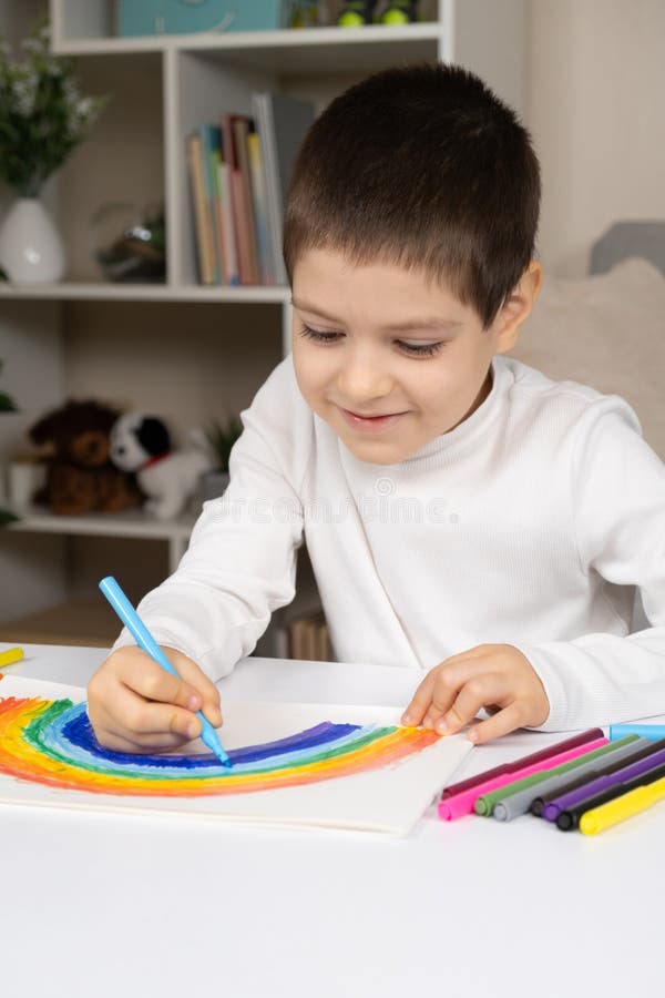 A Small Child Draws a Rainbow with Felt-tip Pens in a Sketchbook while ...