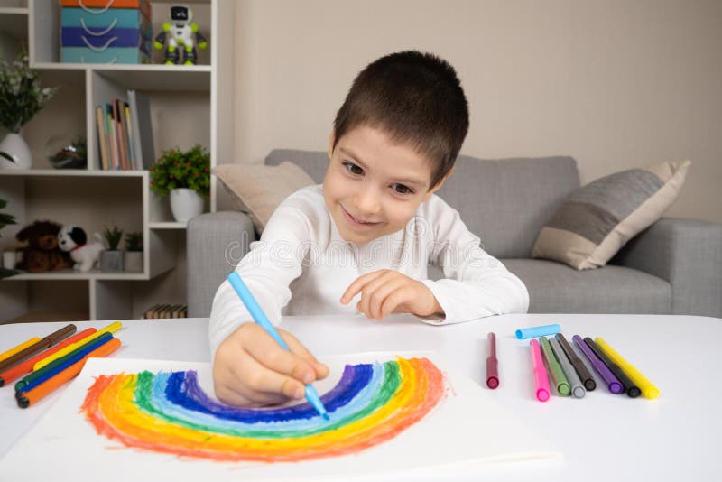 A Small Child Draws a Rainbow with Felt-tip Pens in a Sketchbook while ...