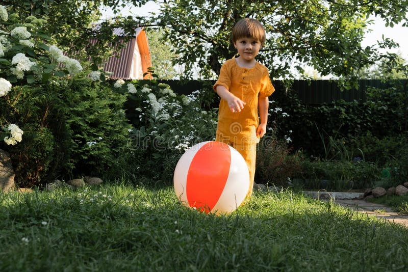 Small Child Playing with Beach Ball in Backyard. Stock Photo - Image of ...