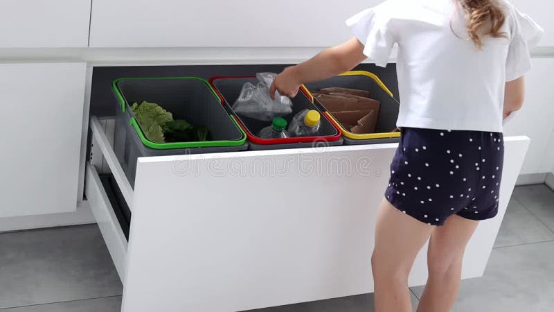 A Small Child Sorts Garbage in Containers in the Kitchen in Slow Motion ...