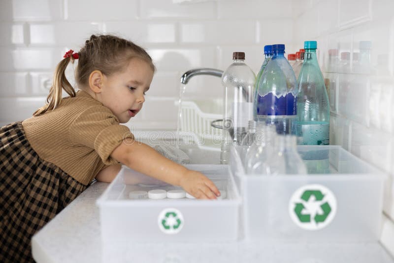 A Small Child Sorts Plastic into Boxes with a Recycling Sign. in the ...