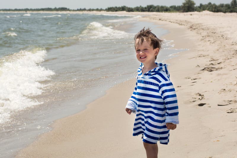A Small Child is Standing on the Seashore Looking and Smiling, Stock ...