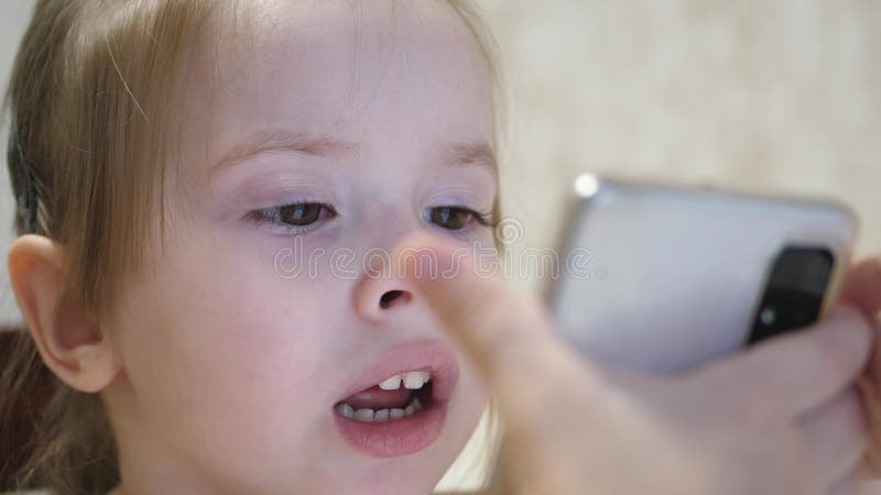 A Small Child is Talking on the Phone Via Video Calling. Kid ...