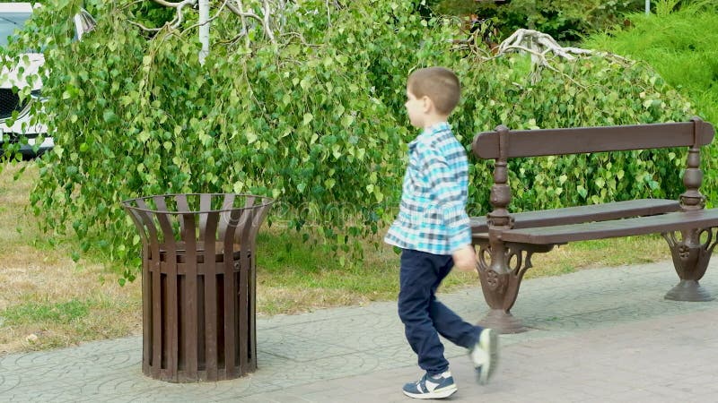 A Small Child Throws Paper Trash into the Trash Bin. Garbage Sorting ...