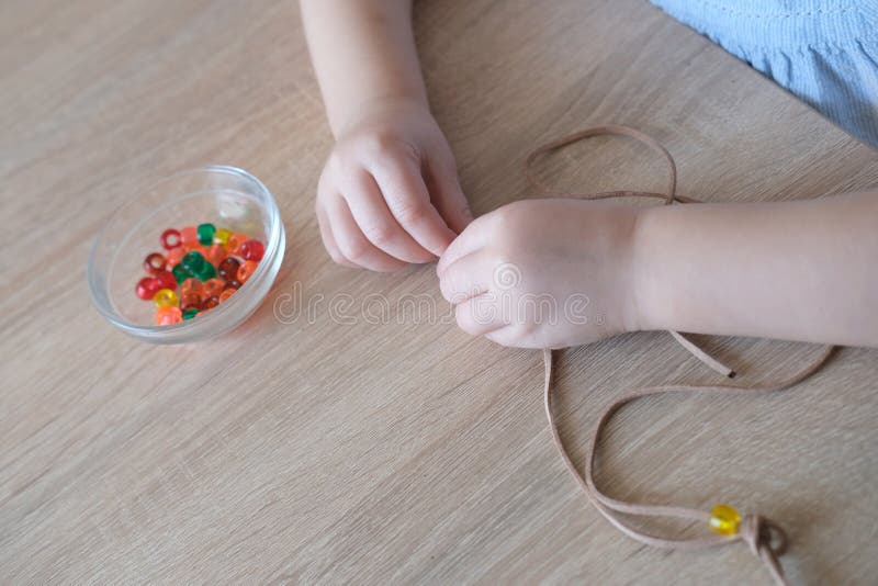 Small Child, Toddler Stringing Colored Plastic Beads on String, Kid`s ...