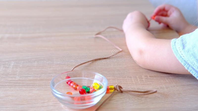 Small Child, Toddler Stringing Colored Plastic Beads on String, Kid`s ...