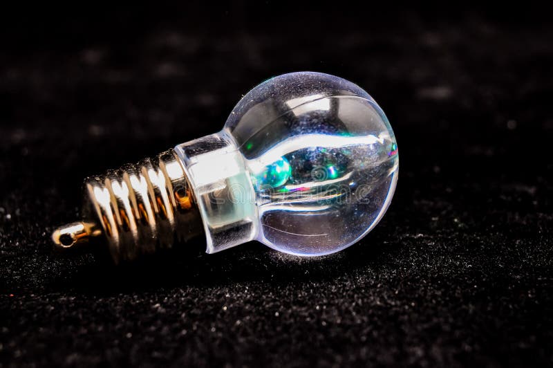 A Small, Clear, Light Bulb is Sitting on a Black Surface Stock Photo ...