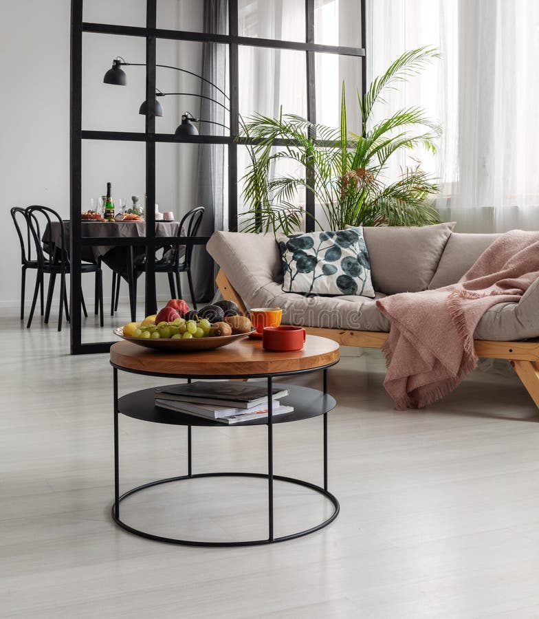 Small Coffee Table in Front of Scandinavian Futon Sofa with Patterned ...