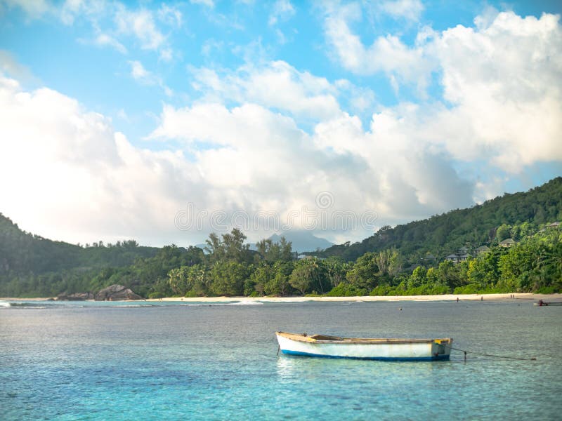 Small Colorful Boat Anchored Off a Seychelles Beach with Distant Stock ...