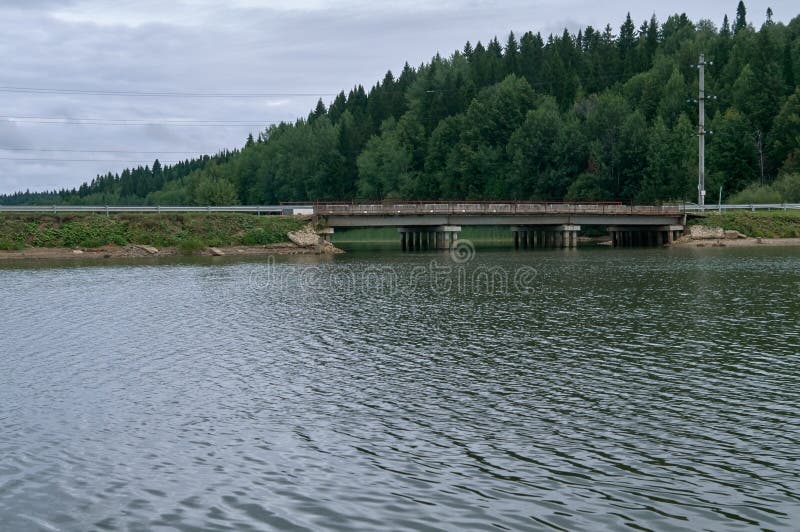 Small Concrete Bridge Over the River or Lake with Dense Forest on ...