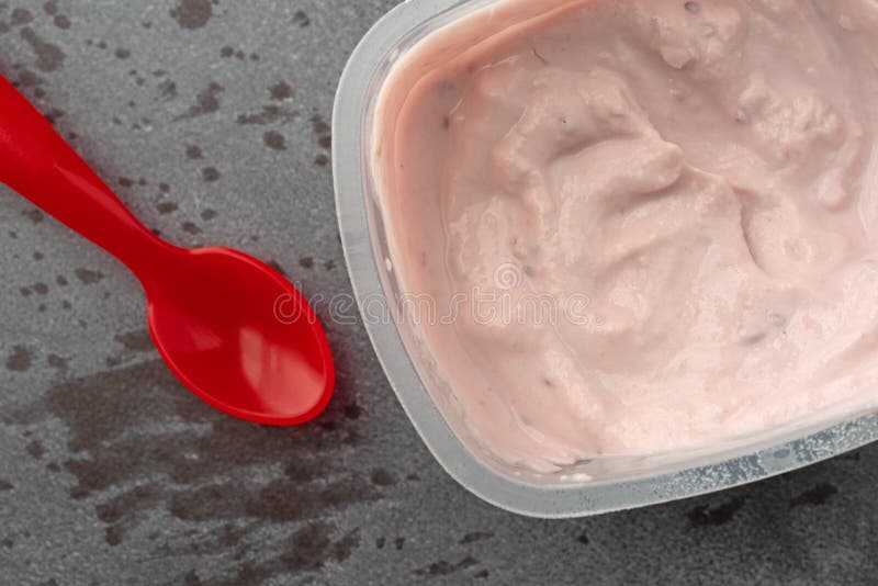 Small Container of Red Raspberry Yogurt with a Spoon To the Side on a ...
