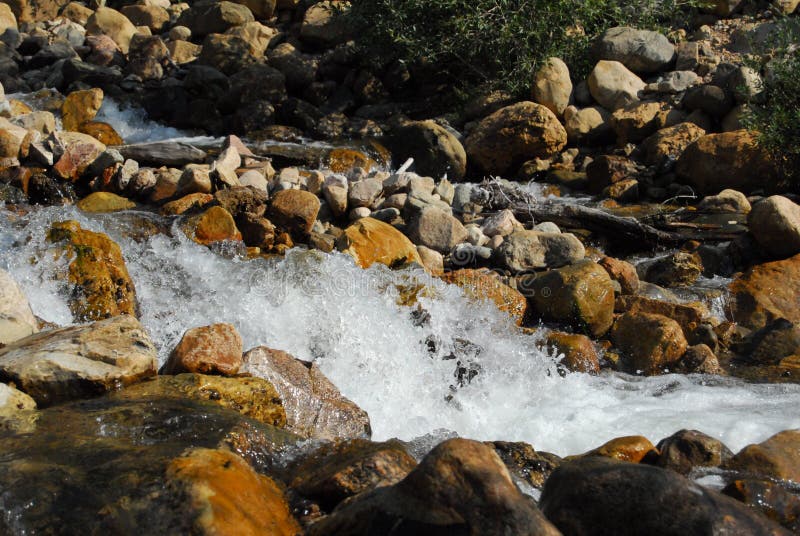 A rushing creek over rocks stock photo. Image of colors - 137320944