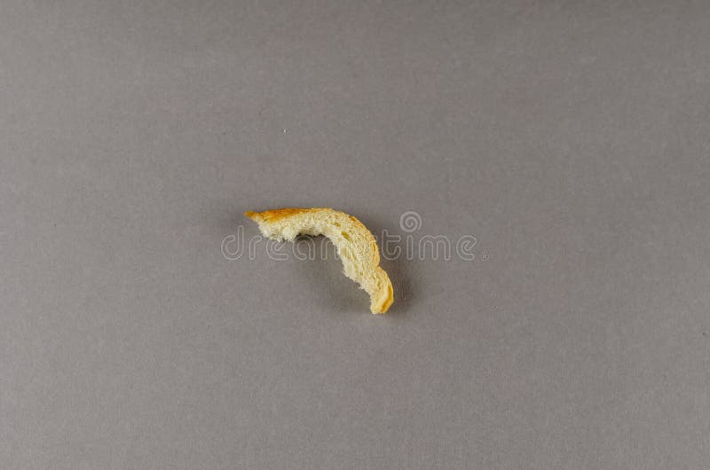 A Small Crust of Bread Against a Gray Background Stock Photo - Image of ...