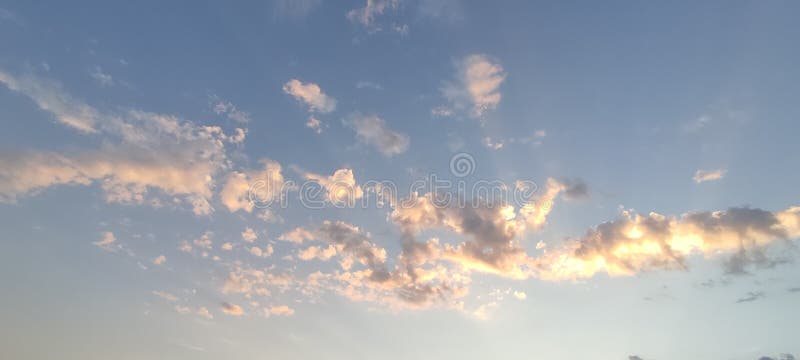 Small Cumulus Clouds Illuminated by Bright Orange and Yellow Rays of ...