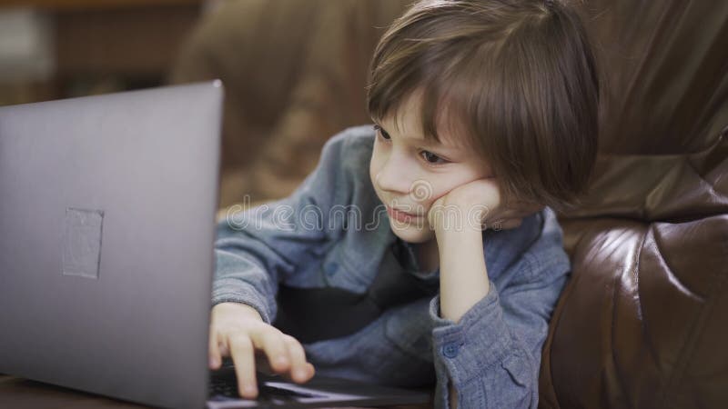Small Boy Working on a Laptop Computer on the Leather Sofa Stock Video ...