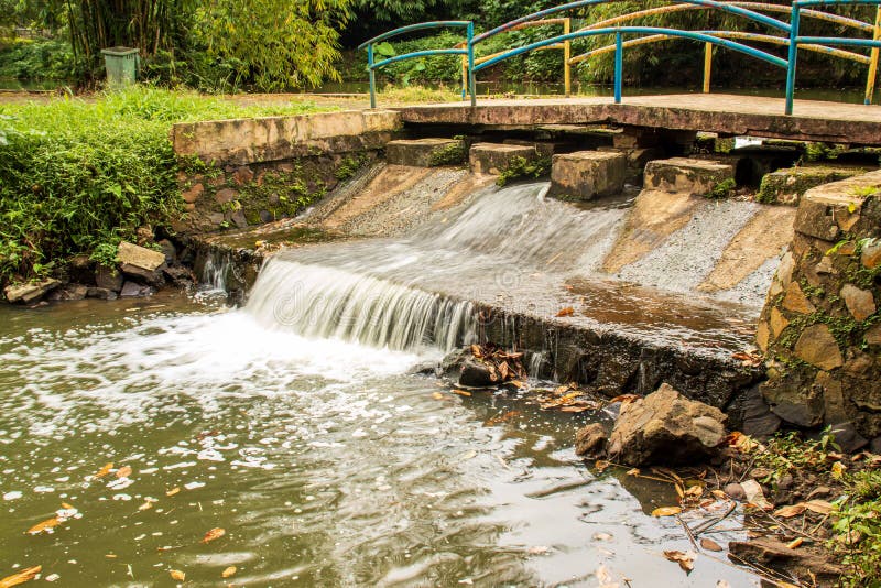 A Small Dam with a Bridge Over it with a Stream of Water Flowing Below ...