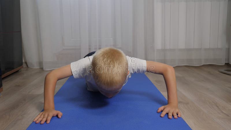 A Small Boy is Doing Push-ups from the Floor at Home, Training a Small ...