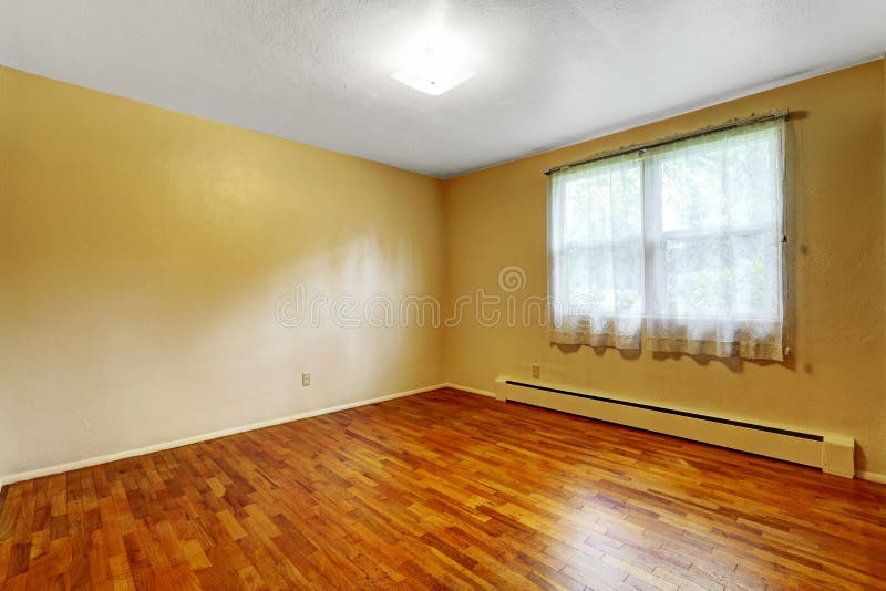 Small Empty Basement Room with Hardwood Floor and Beige Walls Stock ...
