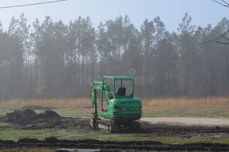 A Small Excavator Digging a Ditch on a Construction Site Stock Photo ...