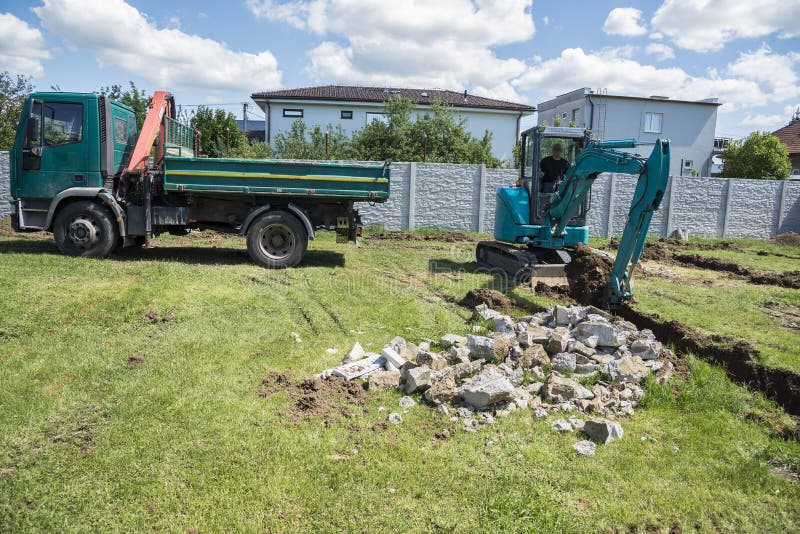 Small Excavator is Digging a Foundation for a House Stock Photo - Image ...