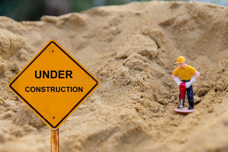 Small Figure Digging Concrete Street with Under Construction Message ...