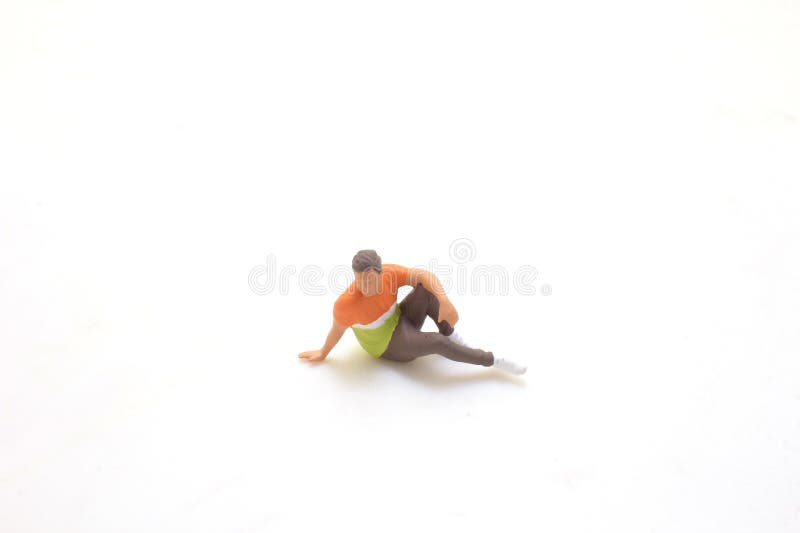 Small Figure Performing a Stretch Alone with a Plain Backdrop Stock ...