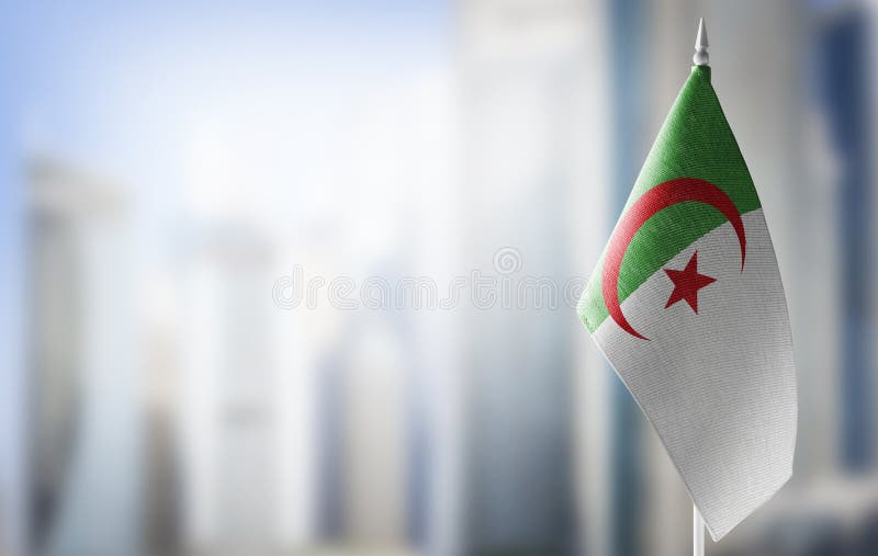 A Small Flag of Algeria on the Background of a Blurred Background Stock ...