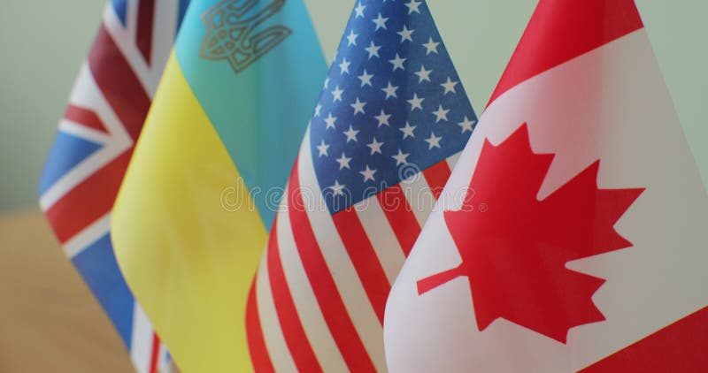 Small Flags of Different Countries on Table. Flags of Canada, American ...