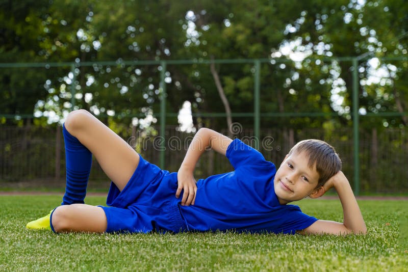 A Small Football Player is Lying on a Green Football Field Stock Image ...