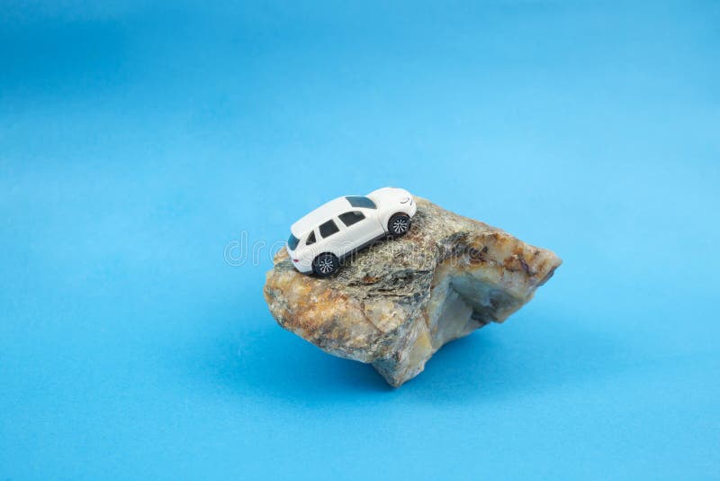 Small Generic Suv Model Car Climbing a Rock in Balance on Blue ...