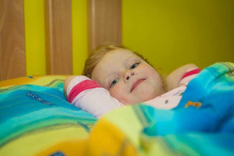 Small Girl in Sheets on a Wooden Bed Stock Image - Image of pillow ...