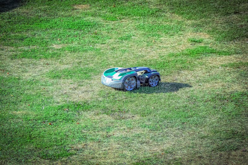 Small Green Robot Lawn Mower on a Large Green Grass Field on Sunny Day ...