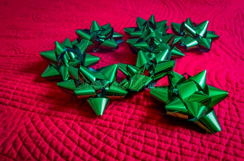 A Small Grouping of Green Present Bows on a Red Quilt Stock Image ...