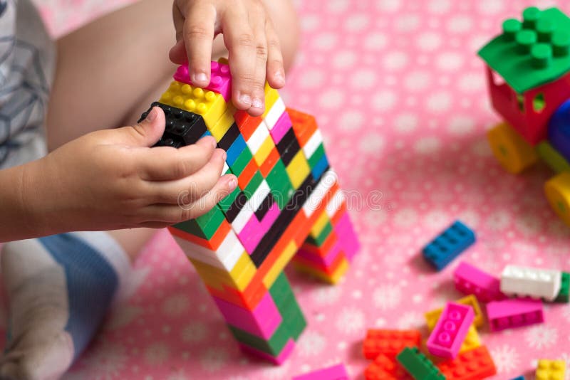 Small Hands of the Child Collects the Bright Plastic Colored Designer ...