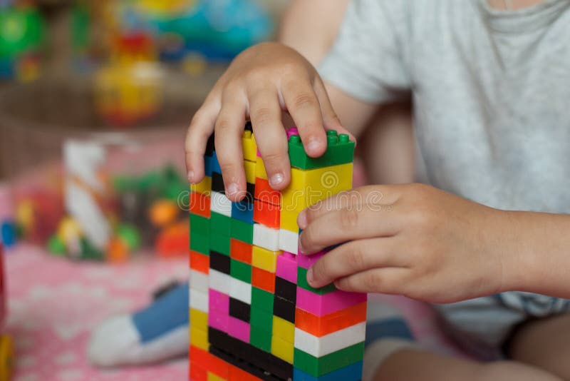Small Hands of the Child Collects the Bright Plastic Colored Designer ...