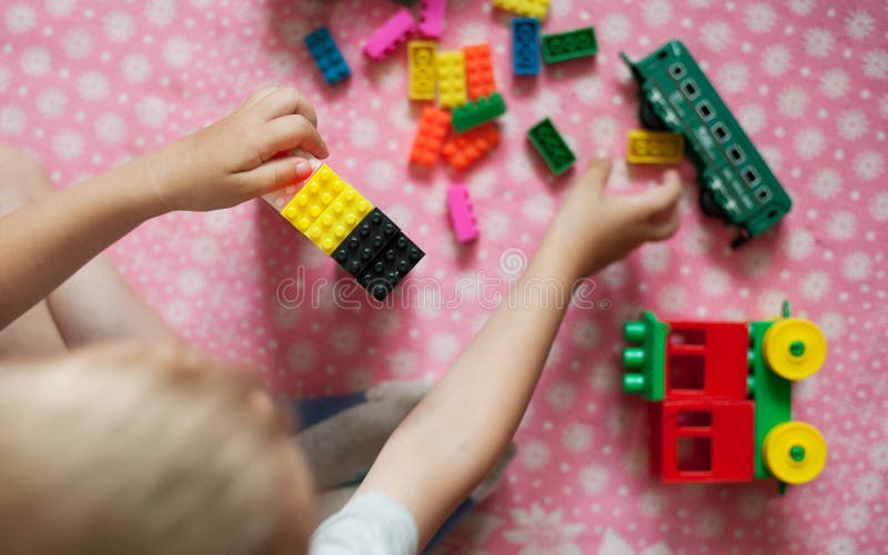 Small Hands of the Child Collects the Bright Plastic Colored Designer ...
