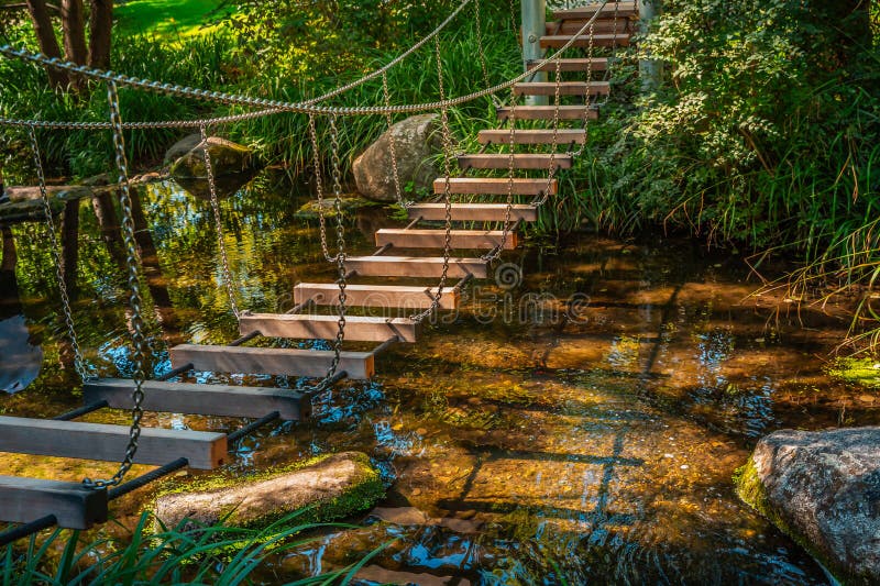 Small Hanging Bridge in a Garden or Park Over Small River or Pond Stock ...