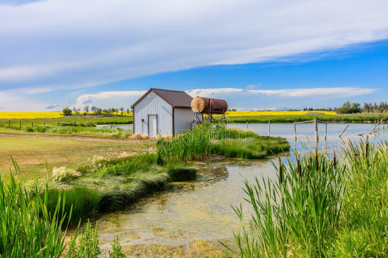 A Small House is on a Farm with a Pond in the Background Stock Photo ...