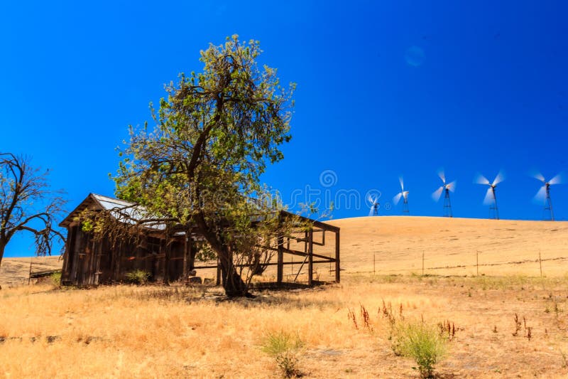 A Small House is on a Hill with a Windmill in the Background Stock ...
