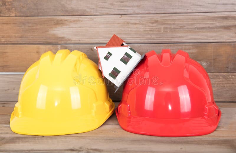 Small House Model between Two Hard Hats and Hats Stock Image - Image of ...