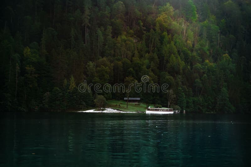 Small Hut Surrounded by the Dense Forest and the Calm Lake with a Boat ...
